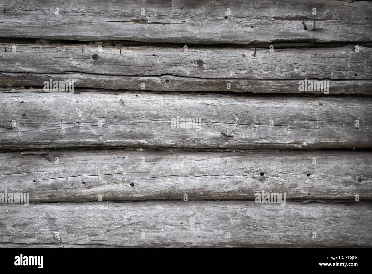 Rough old weathered log cabin background wall closeup with logs and ...