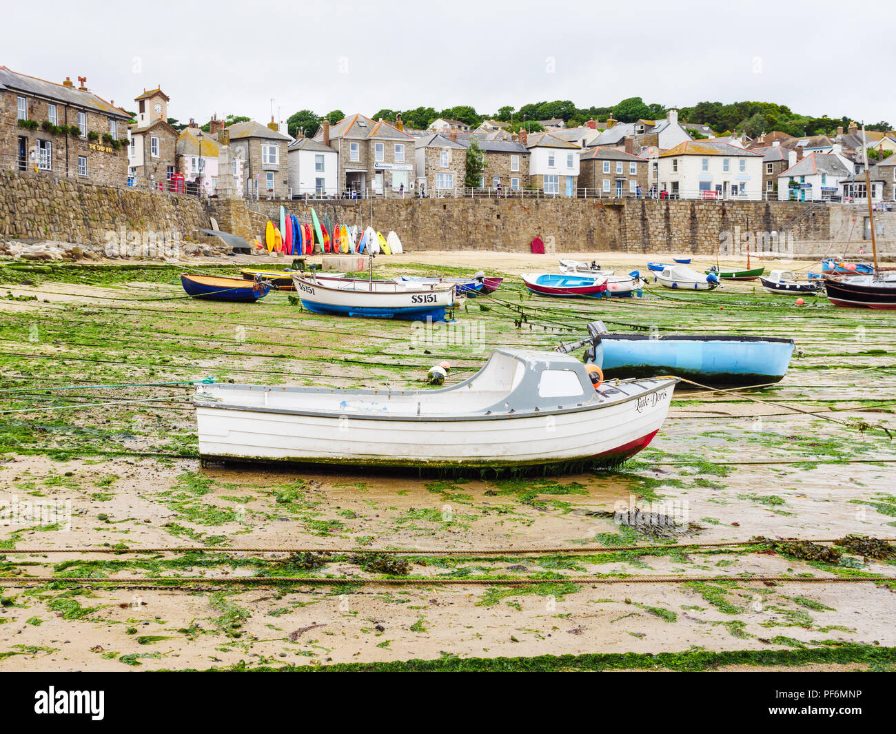 MOUSEHOLE, ENGLAND - JUNE 20: Fishing boats at low tide in Mousehole ...