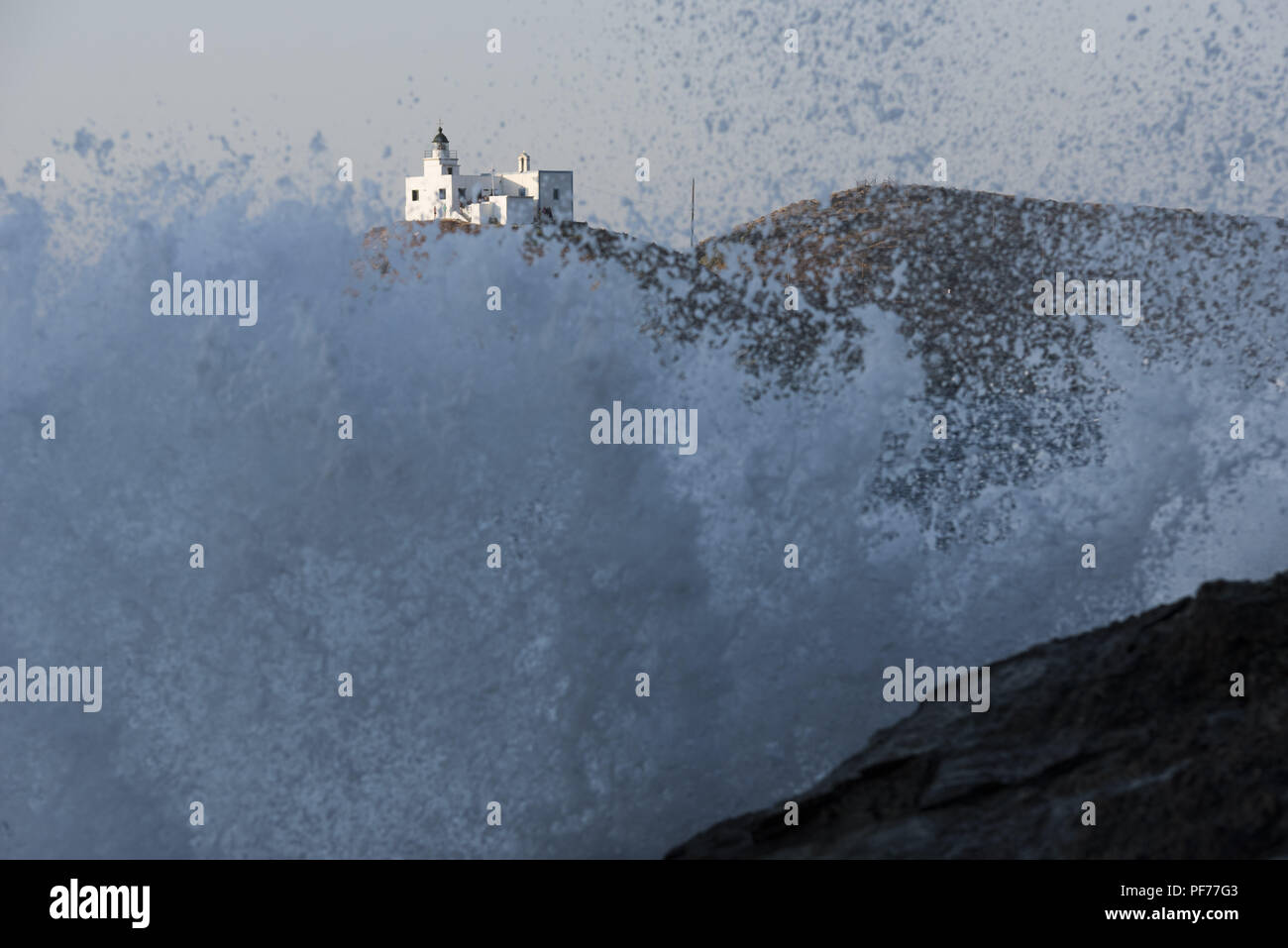 Waves crash on rocks, across a lighthouse. Greece celebrated the ...
