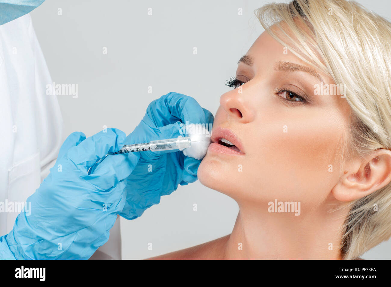 Beautiful girl receiving filler injection in lips. Cosmetic Treatment ...