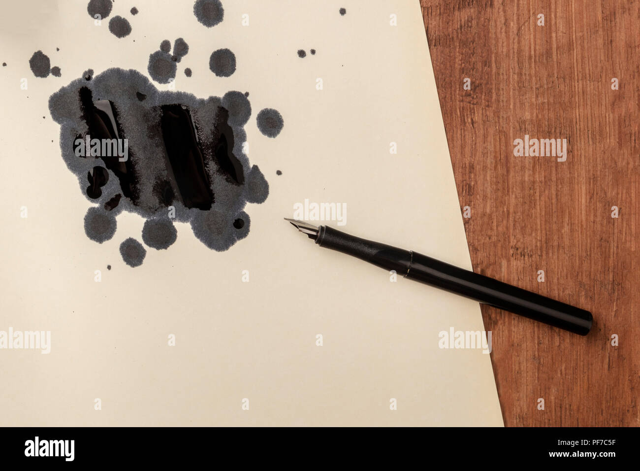 An overhead photo of drops of ink on a sheet of textured off-white ...