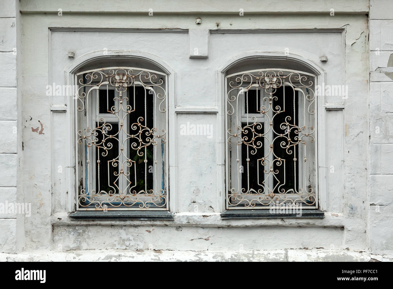 Close-up of a two old windows in old house a mansion made of old white ...