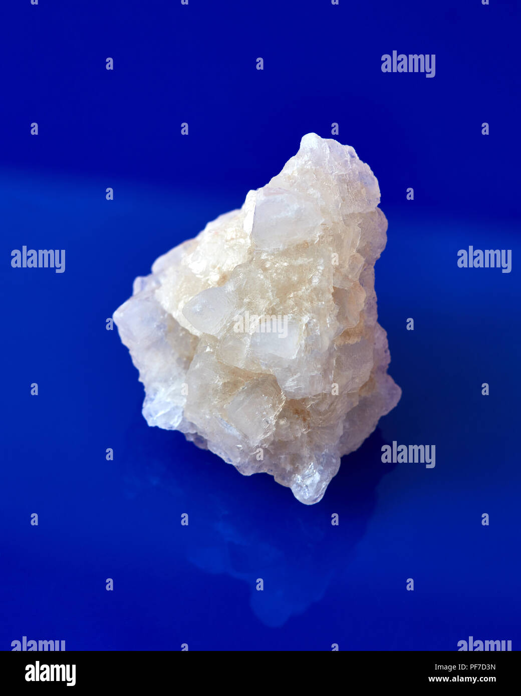 Rock salt of a big piece on a blue background with reflection, place ...