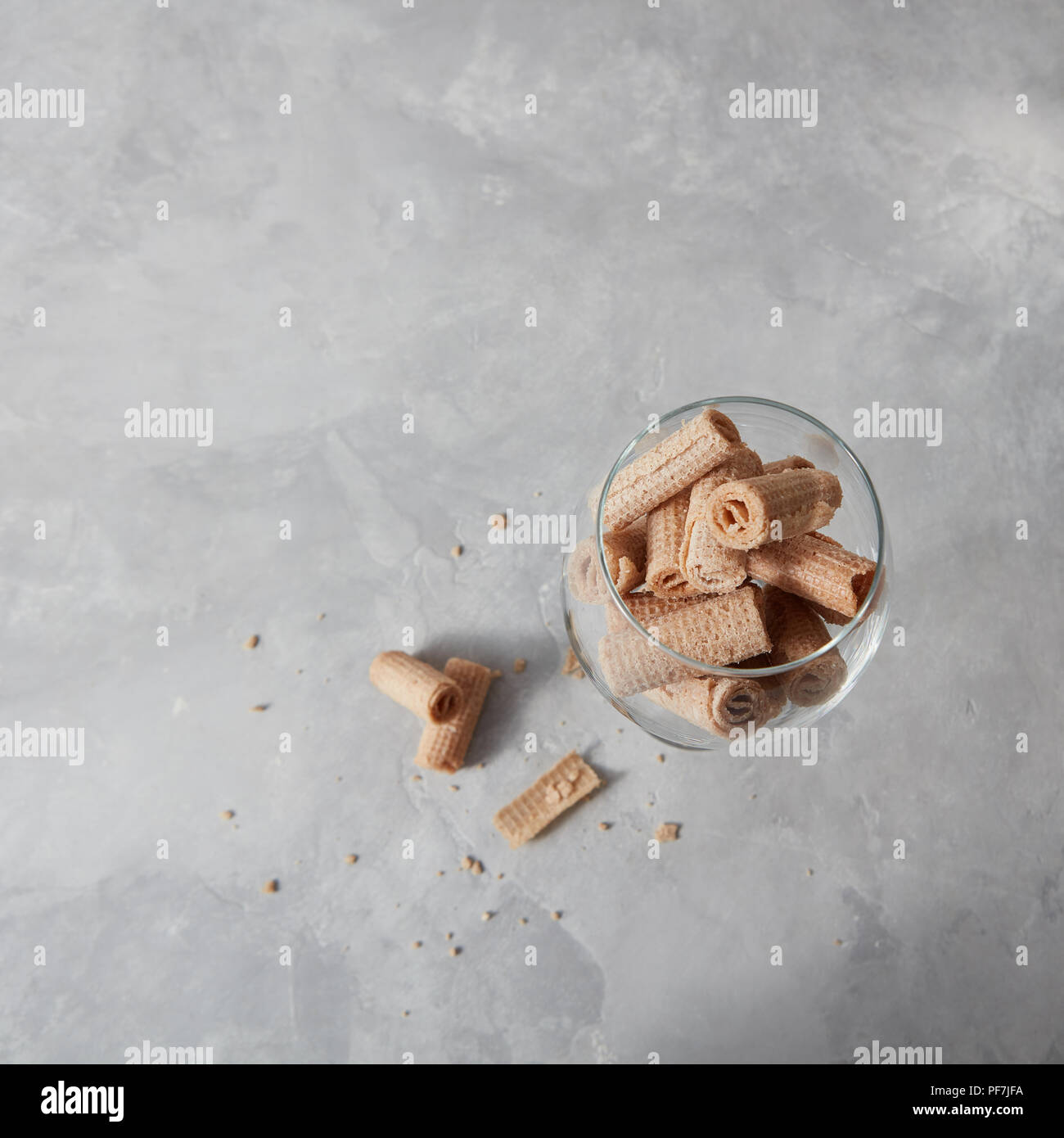 Wafer creamy sticks in a glass cup a on a gray stone background with ...