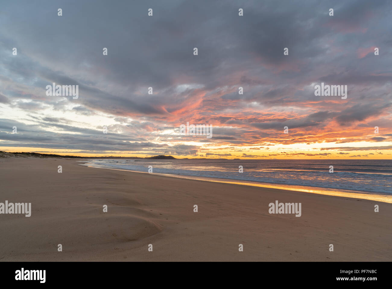 Wide shot of beach sunrise with golden reflections on the sand Stock ...