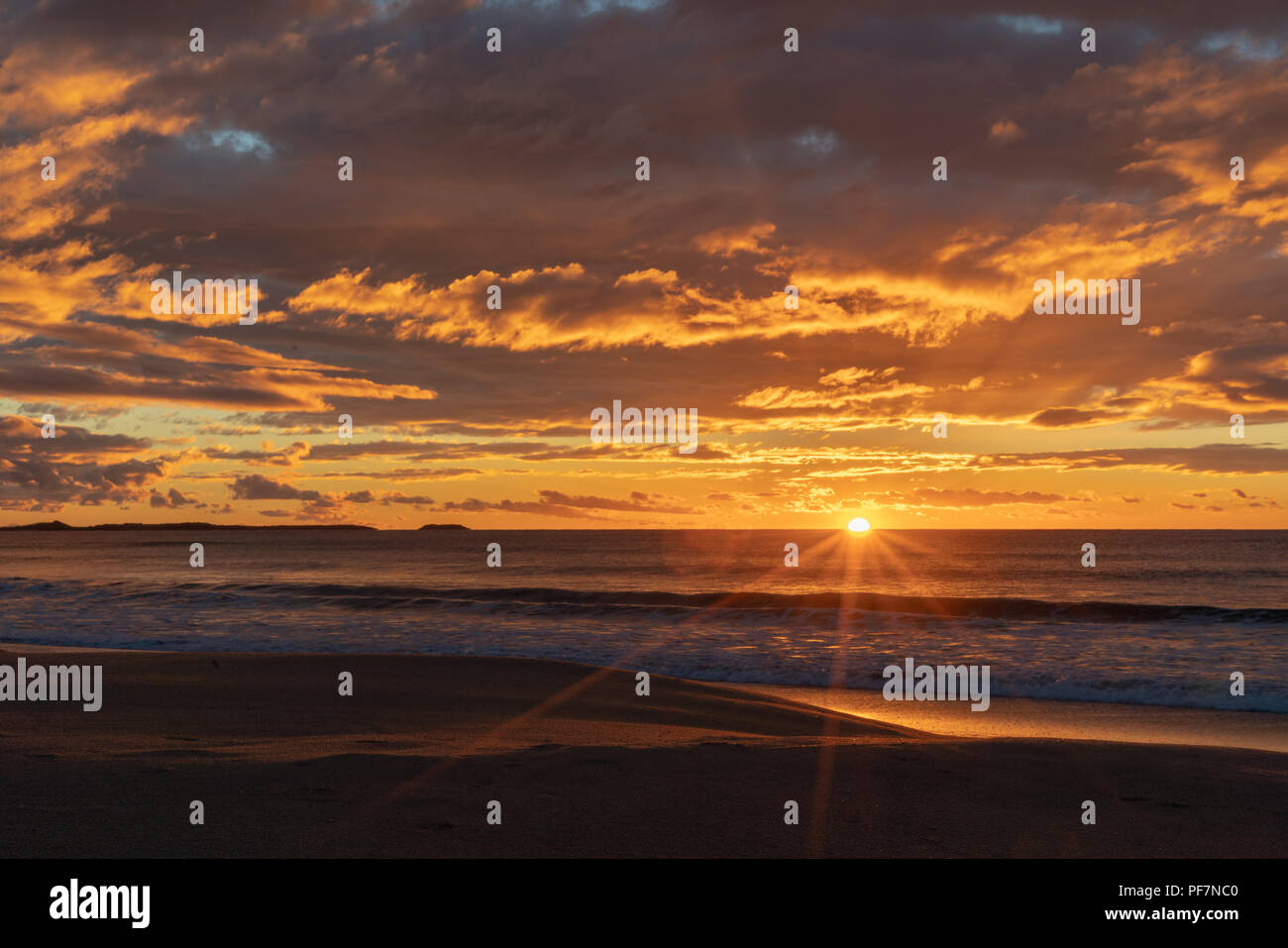 Sunrise with star burst over the ocean Stock Photo - Alamy