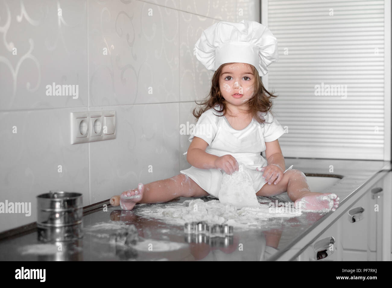 beautiful little girl learns to cook a meal in the kitchen Stock Photo ...