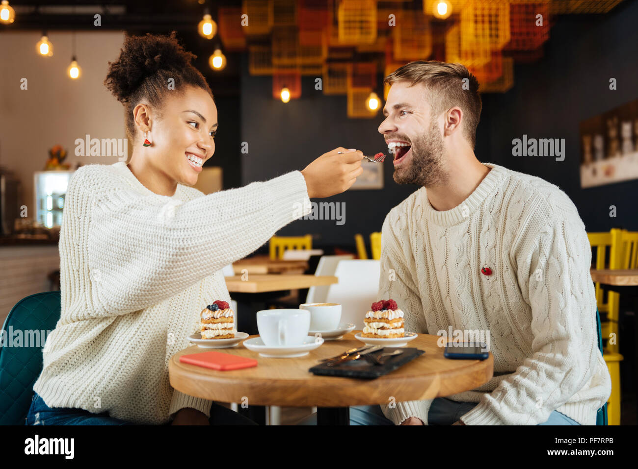 Caring girlfriend giving piece of cake her husband Stock Photo - Alamy