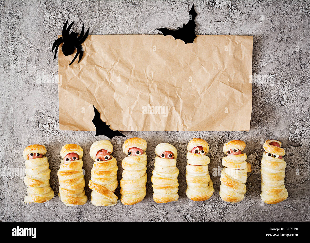 Scary sausage mummies in dough with funny eyes on table. Mockup ...