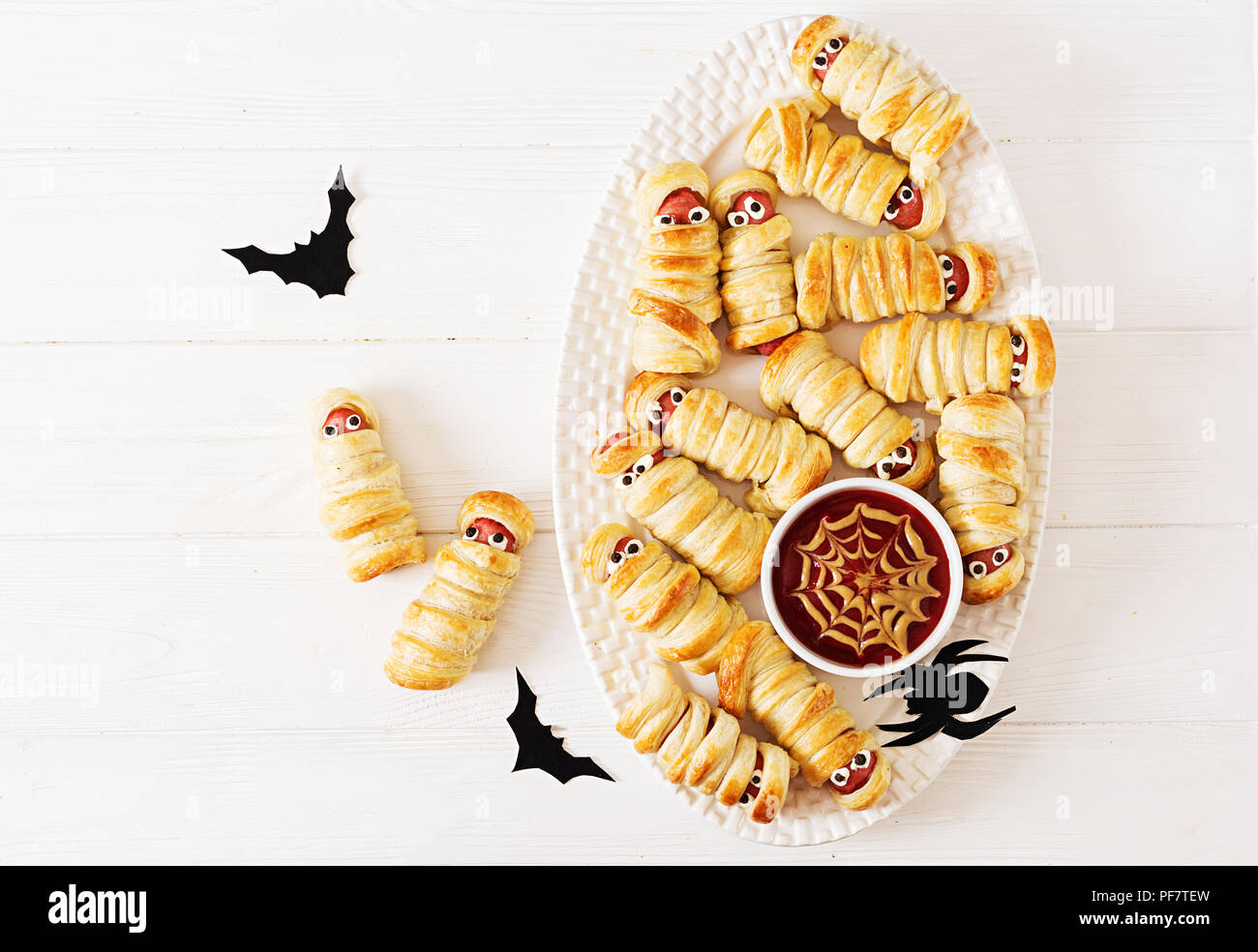 Scary sausage mummies in dough with funny eyes on table. Funny ...