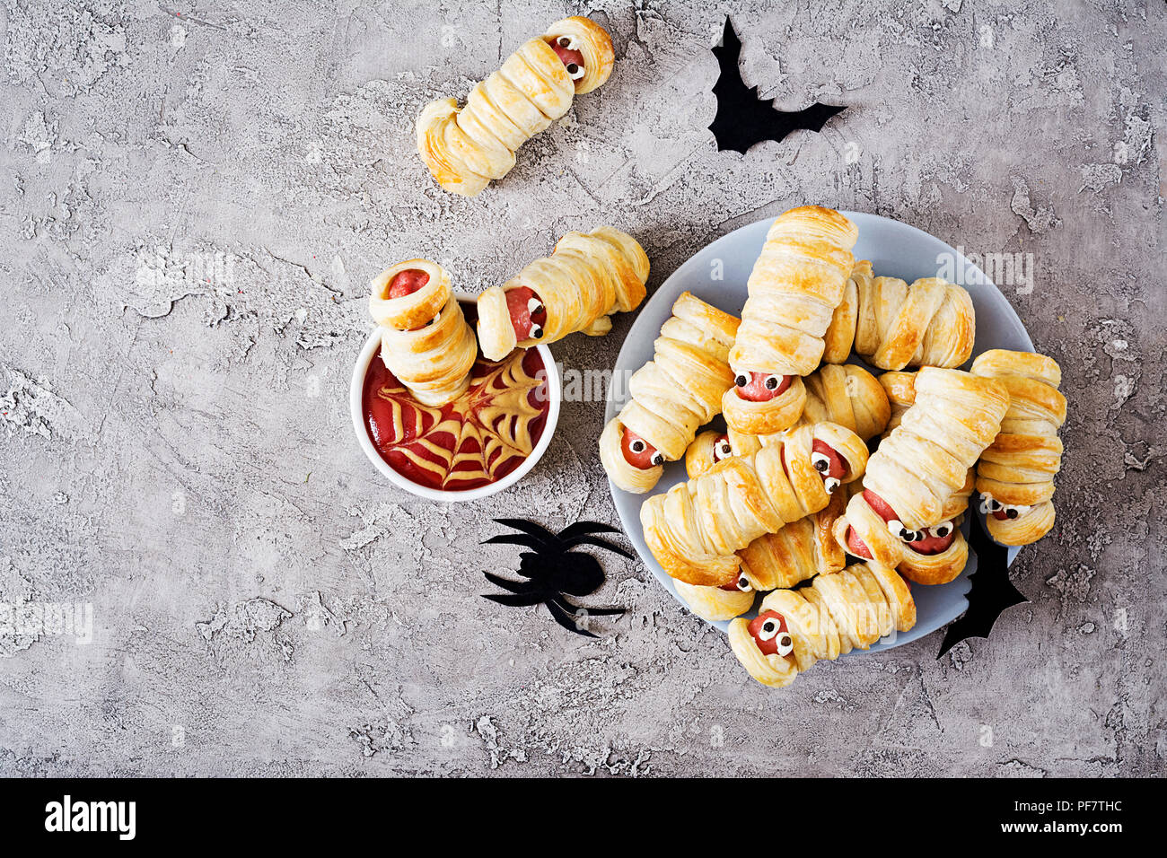 Scary sausage mummies in dough with funny eyes on table. Funny ...