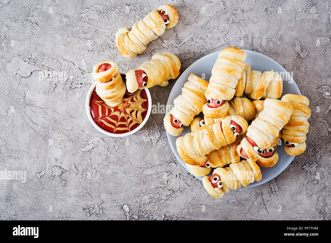 Scary sausage mummies in dough with funny eyes on table. Funny ...