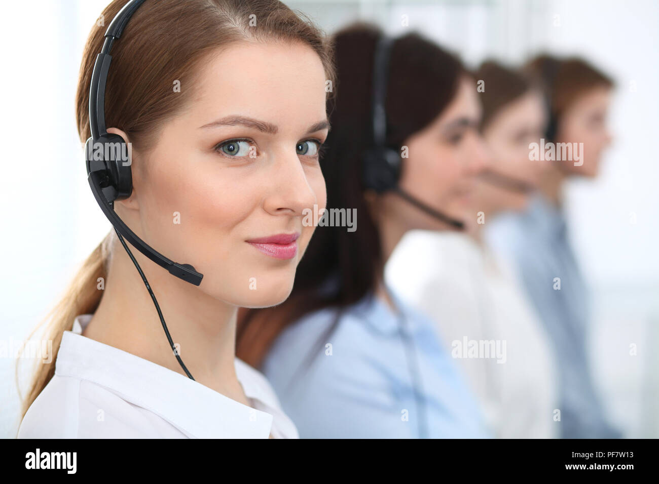 Call center. Beautiful cheerful smiling operator consulting clients ...