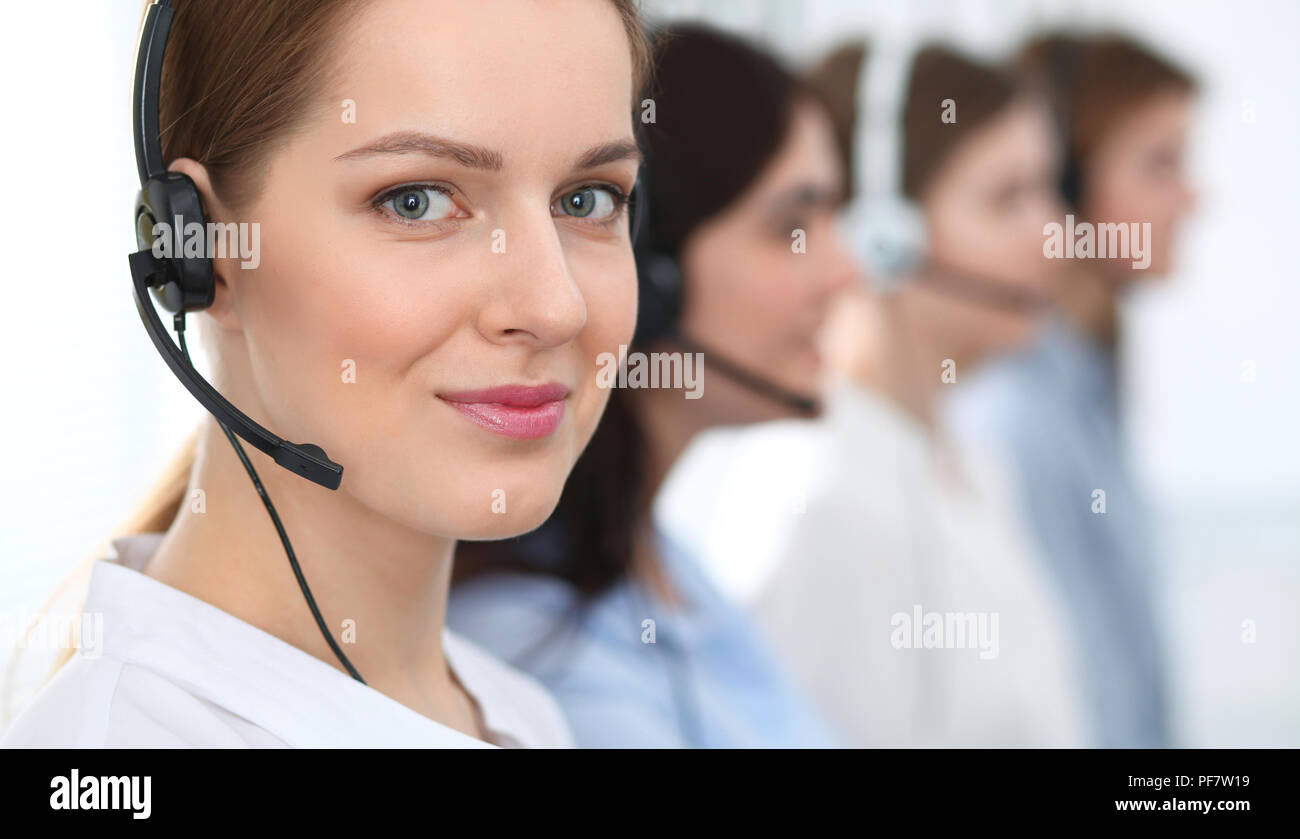 Call center. Beautiful cheerful smiling operator consulting clients ...