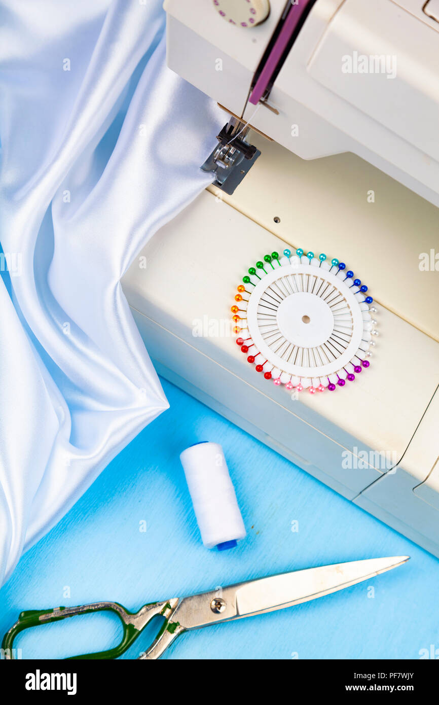 Sewing machine and white satin fabric close-up Stock Photo - Alamy