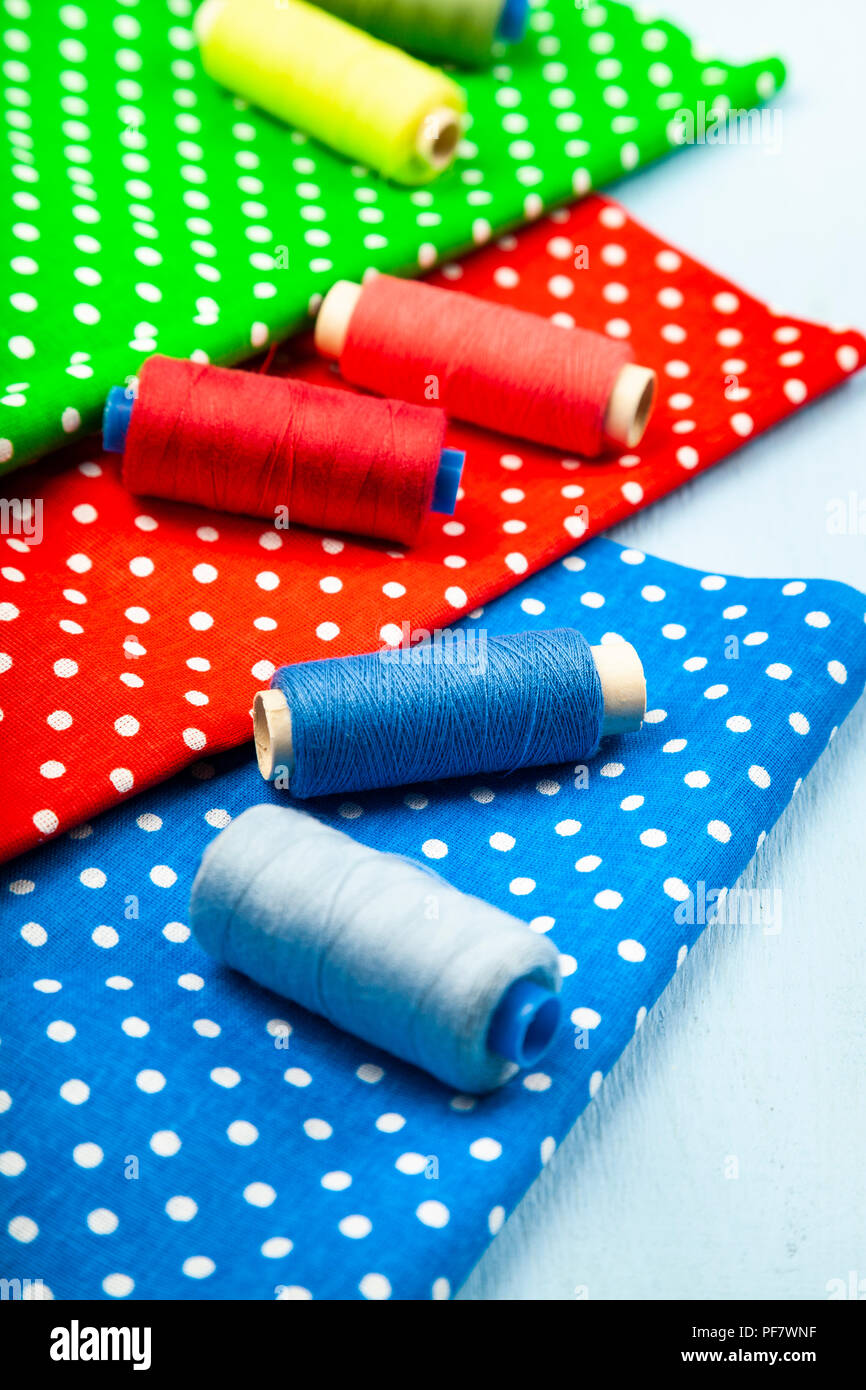 Sewing accessories and multi-colored fabrics on a blue wooden ...