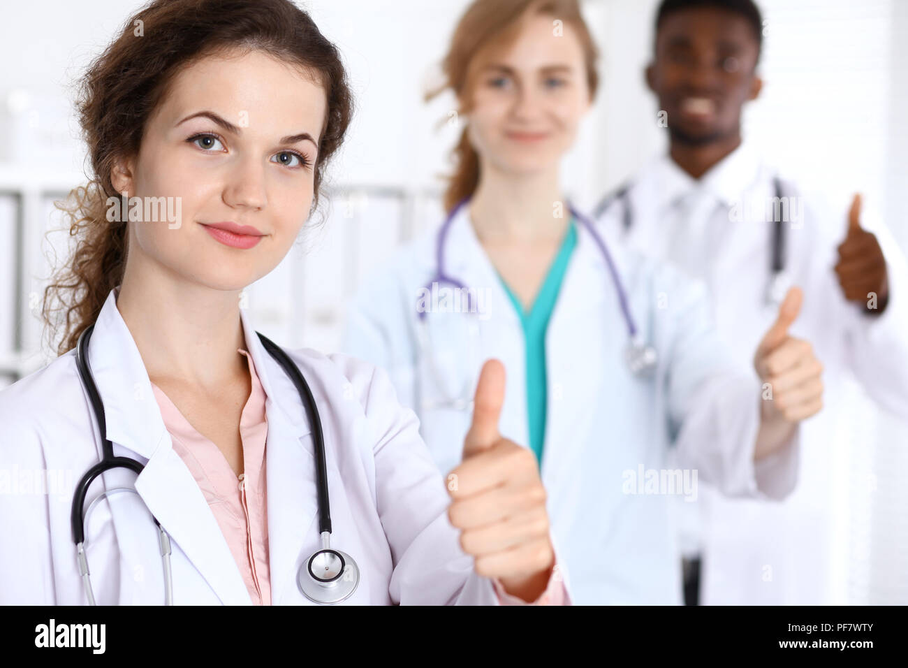 Medical team of confident doctors showing Ok sign with thumbs up ...