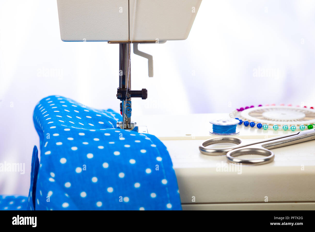 Sewing machine and blue fabric close-up Stock Photo - Alamy