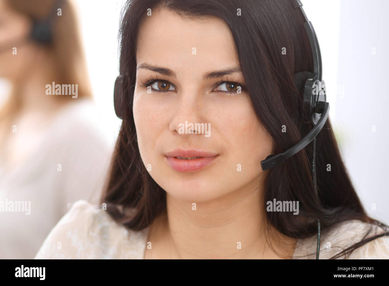 Young businesswoman sitting at desk and while consulting clients ...