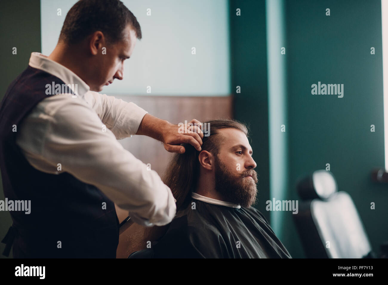 Barbershop with wooden interior. Bearded model man and barber Stock ...