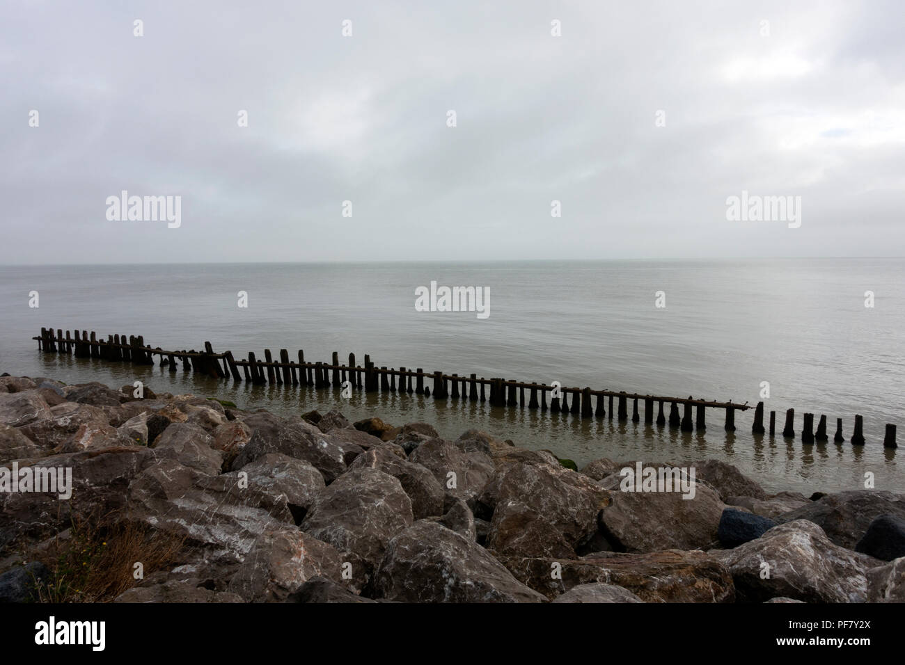 Wooden groynes and rock armour coastal defences Stock Photo - Alamy