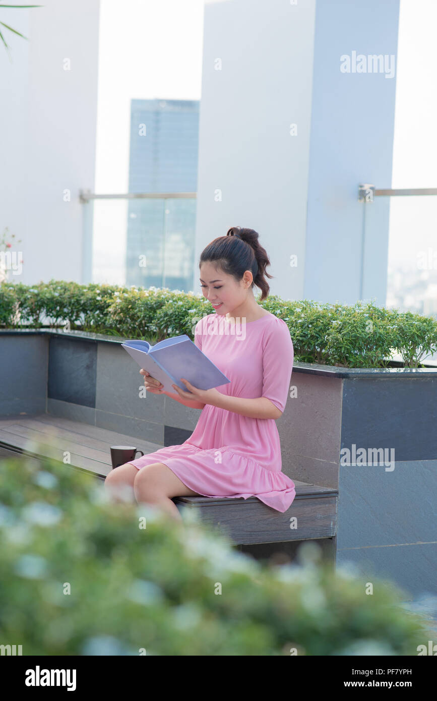 Young Asian executive woman standing and hold folder outside office ... Young Asian executive woman standing and hold folder outside office ...