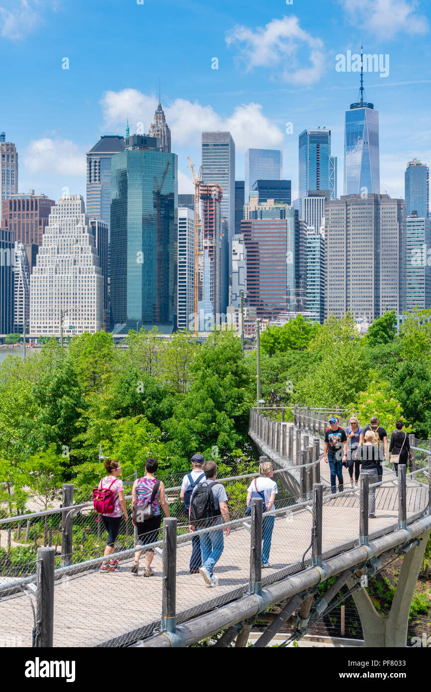 People walking on an walkway towards the Brooklyn Bridge Park in New ...