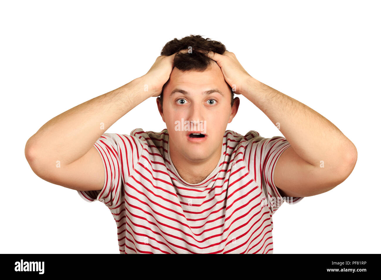 Shocked dazed young man in t-shirt holding head with both hands ...