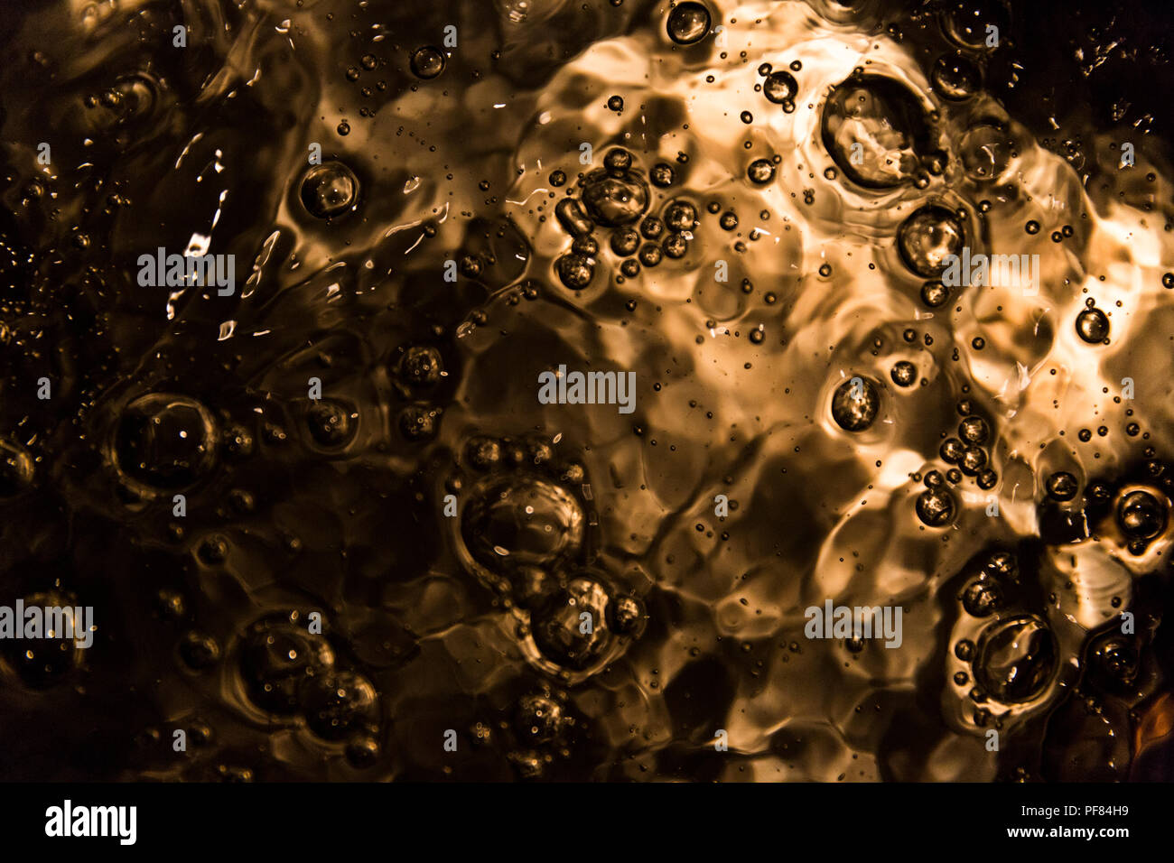 An abstract golden color splashing around in water bath Stock Photo - Alamy