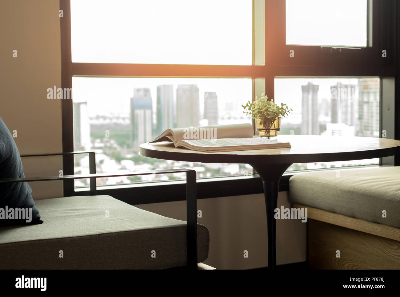 Wooden table with an opened book and plant on window with sunlight and ...