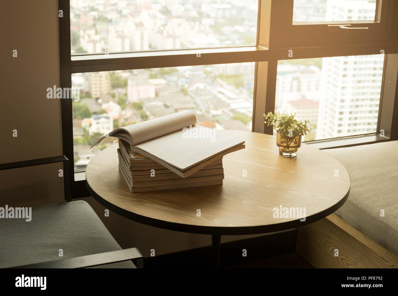 Wooden table with an opened book and plant on window with sunlight ...