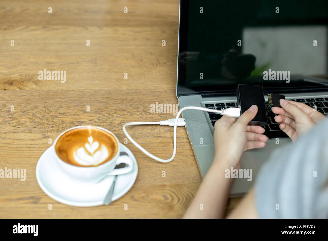 Hand woman inserting memory card into card reader with laptop and ...