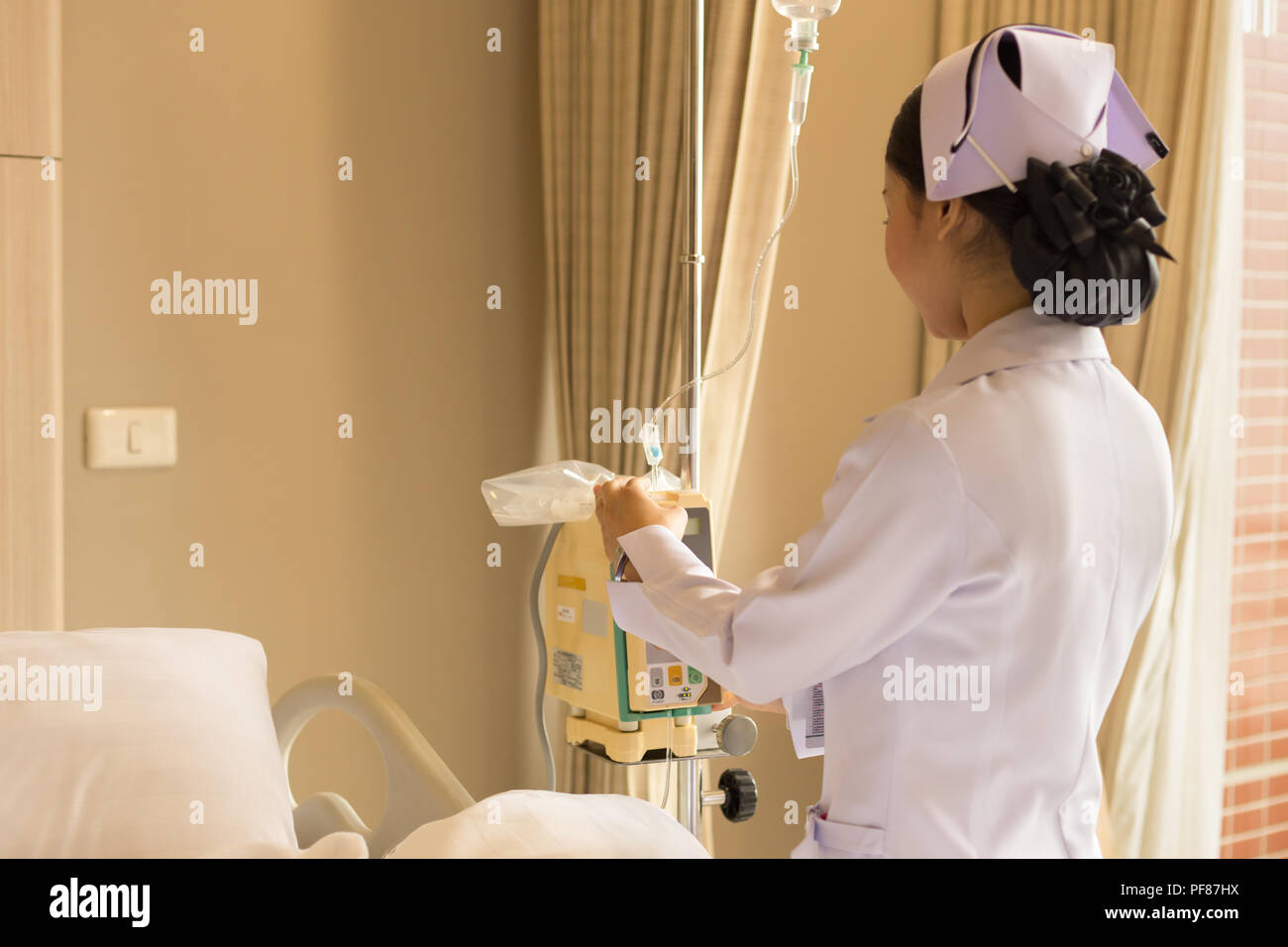 Nurse's hand operating IV machine in patient room in hospital Stock ...