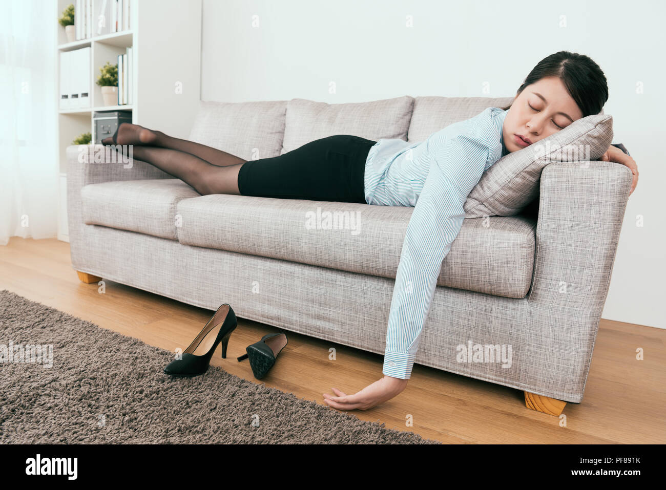 she is extremely tired from work and fall in sleep on the sofa after ...