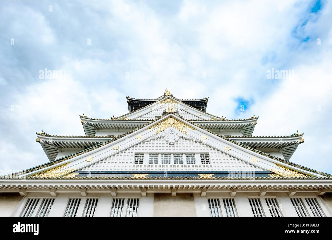 The famous heritage, Osaka castle under bright blue dramatic cloudy sky ...