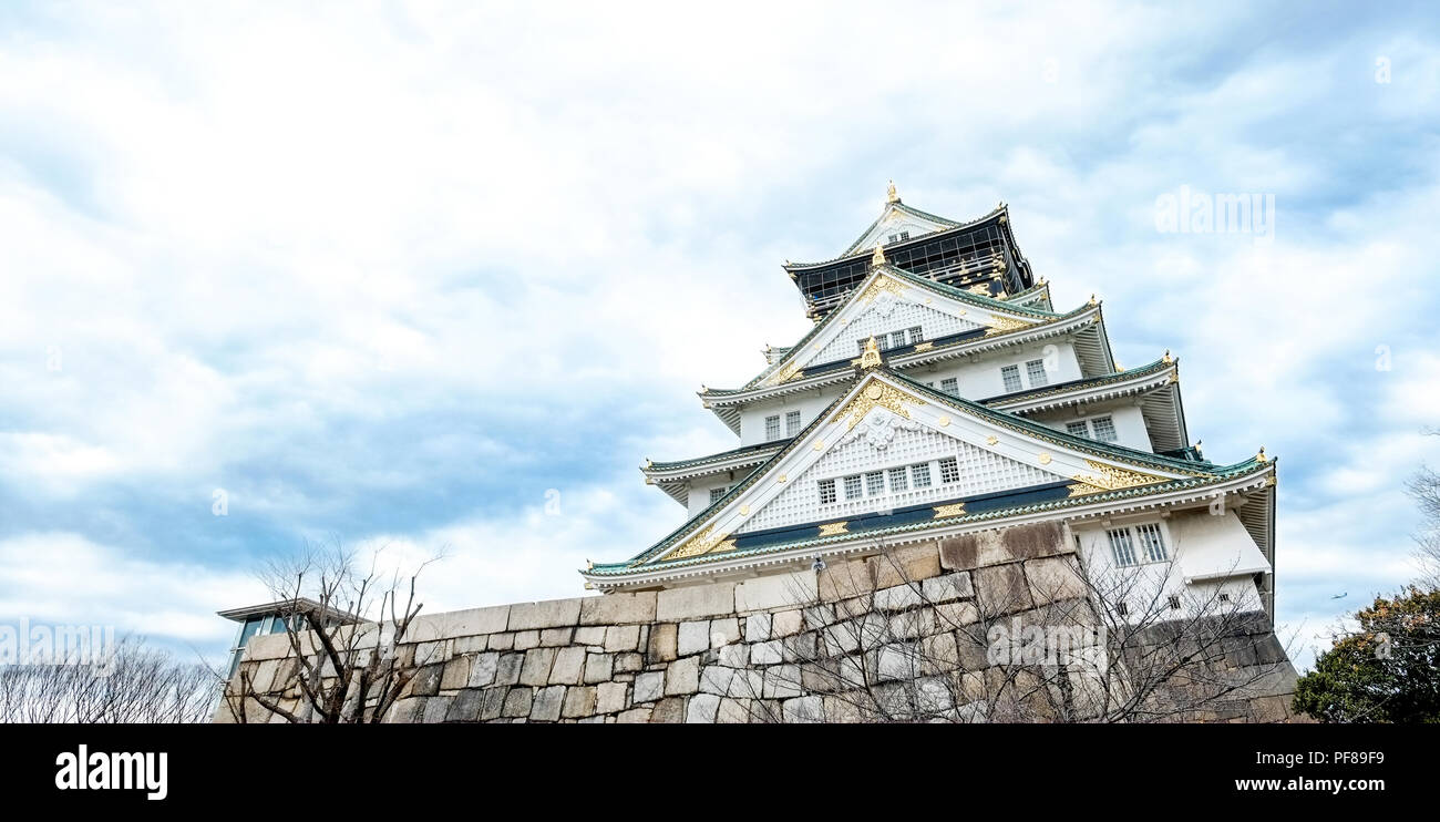 The famous heritage, Osaka castle under bright blue dramatic cloudy sky ...