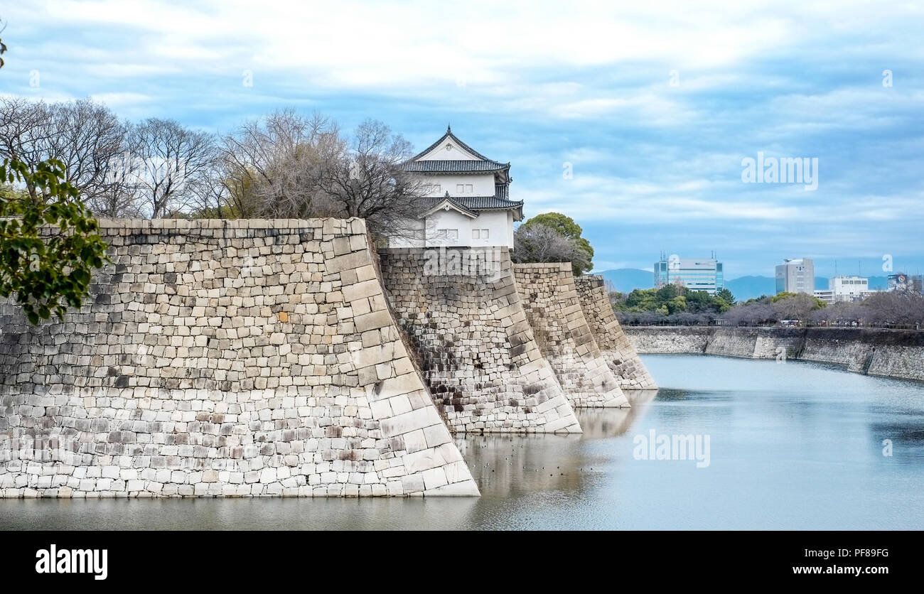 The famous heritage, Osaka castle under bright blue dramatic cloudy sky ...
