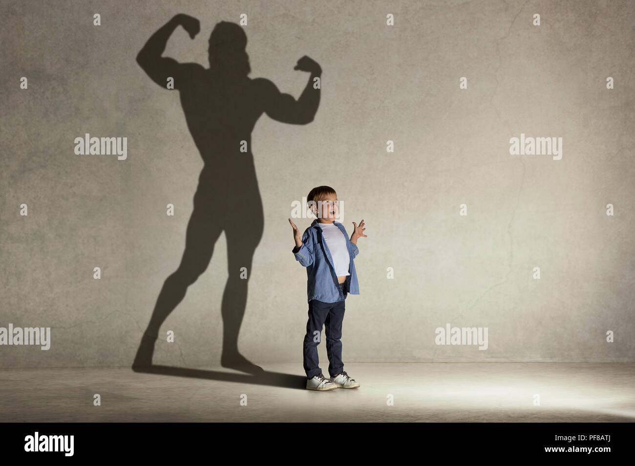 The little boy dreaming about athletic bodybuilder figure with muscles ...