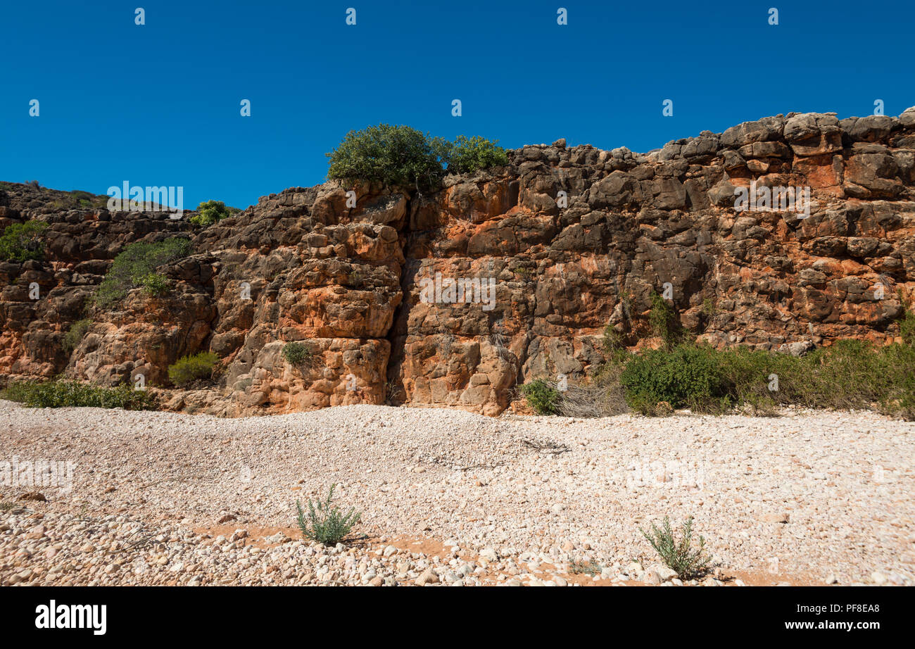 Red Stone walls and white rocks at the bottom of Mandu mandu gorge ...