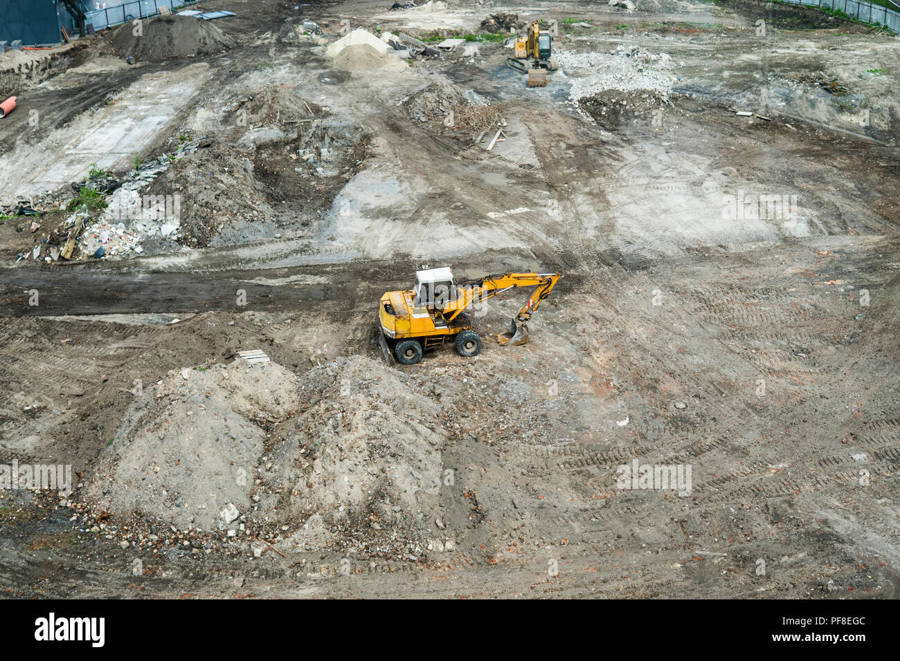 Yellow excavator standing on a ground during construction of a new ...