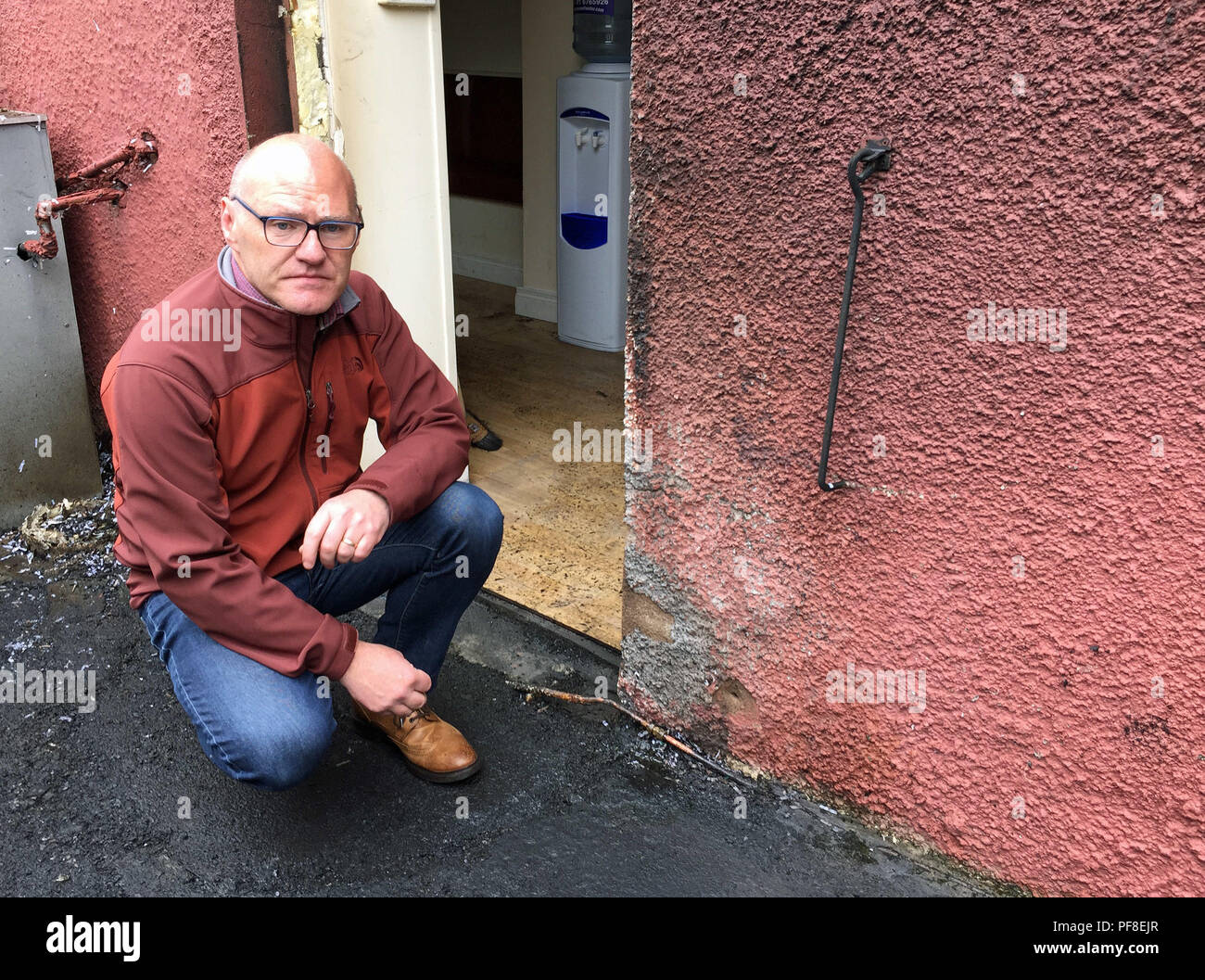 West Belfast MP Paul Maskey inspects the damage caused to Sinn Fein ...