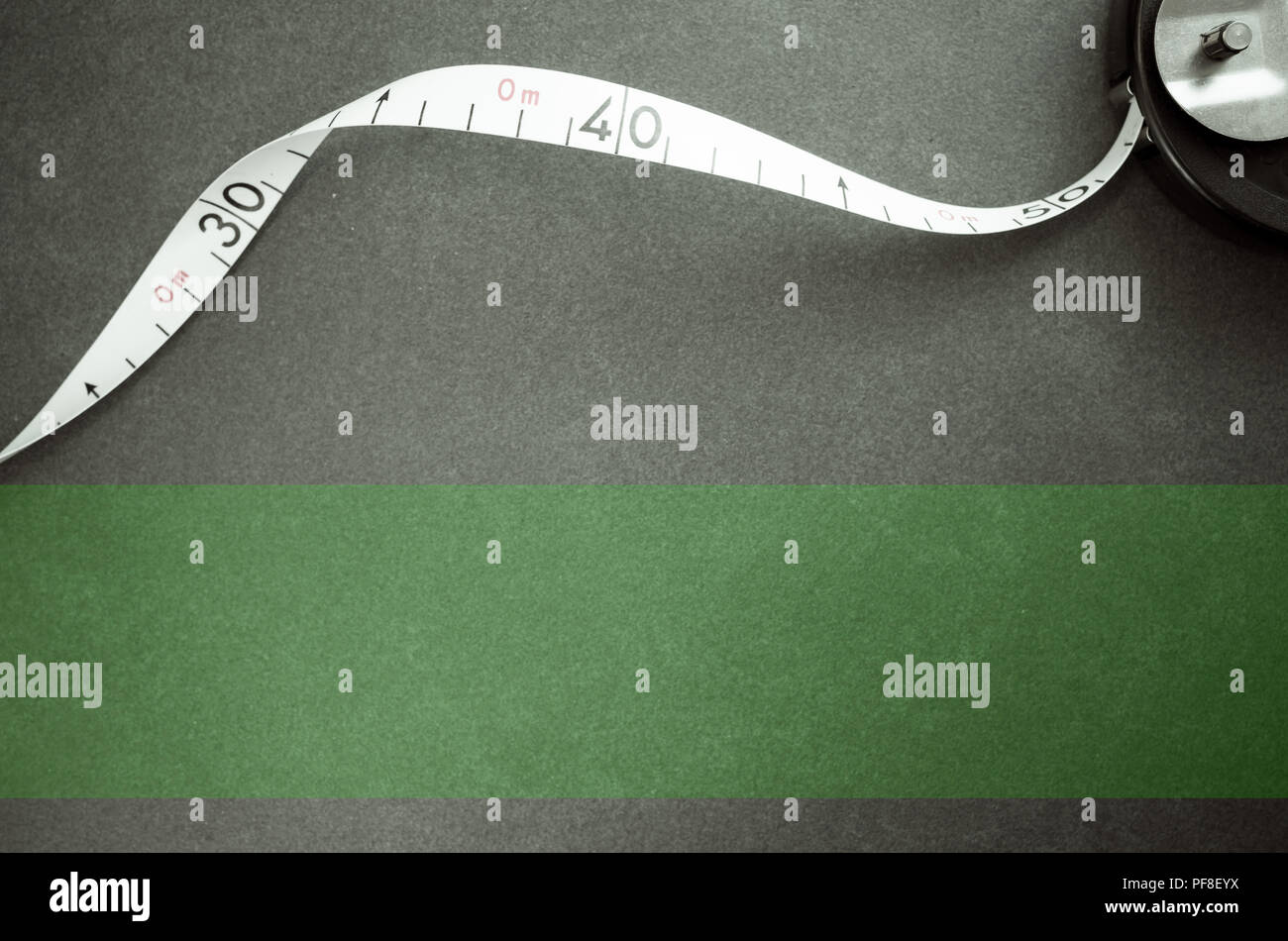 industrial metric measuring tape on a dark worktop surface - top view ...