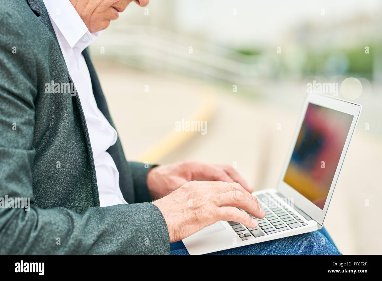 Crop businessman using laptop on street Stock Photo - Alamy