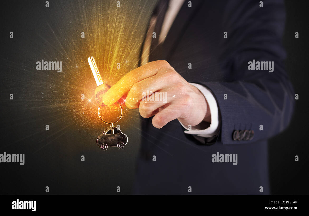 Formal man hand over shiny keys with dark background Stock Photo - Alamy