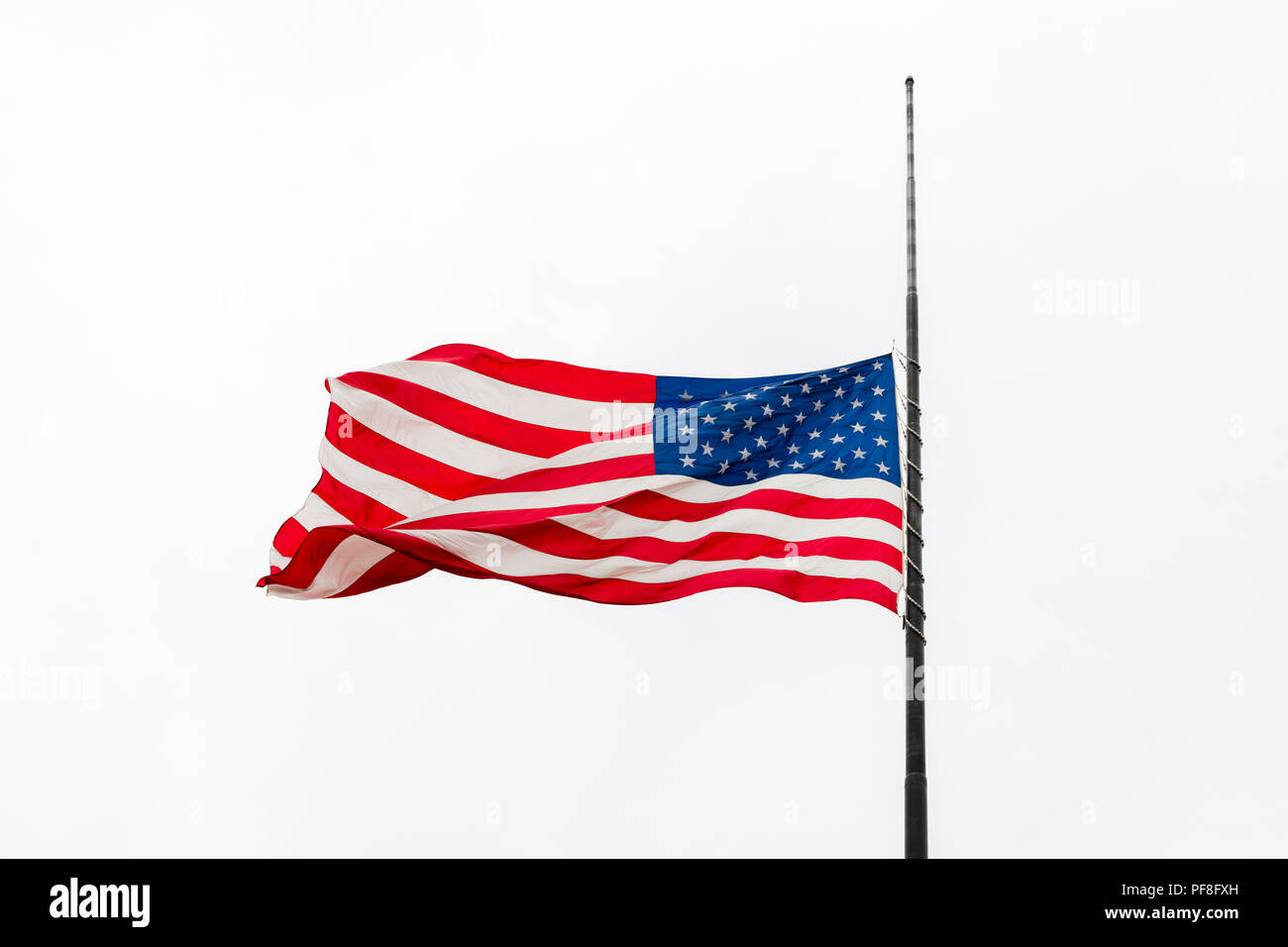 United States Flag Flying at a Half-staff Waving Against Gray Sky Stock ...