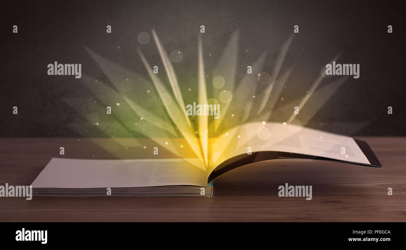 Yellow lights spreading from an open book Stock Photo - Alamy