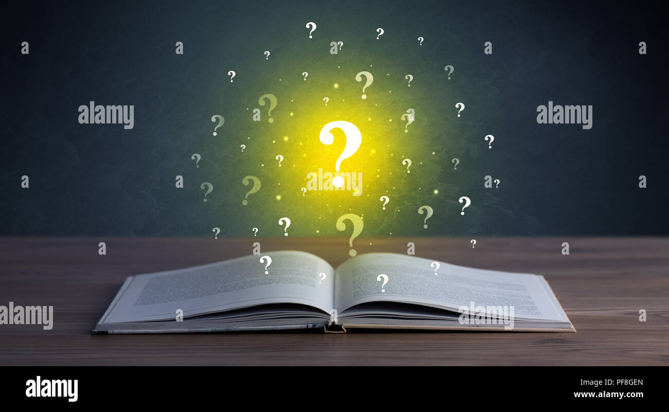 Yellow question marks hovering over open book Stock Photo - Alamy
