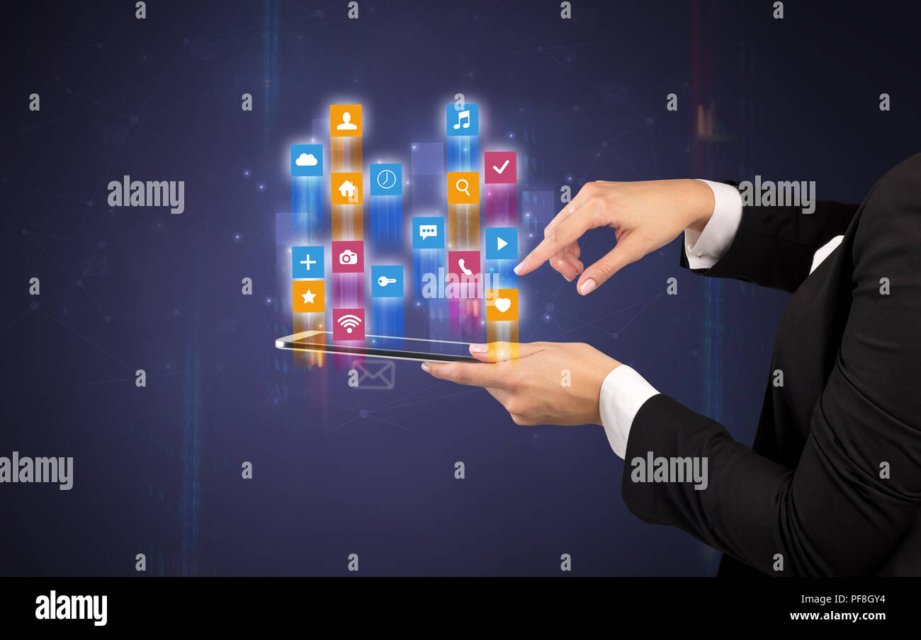 Female elegant hand holding tablet with colourful application icons ...