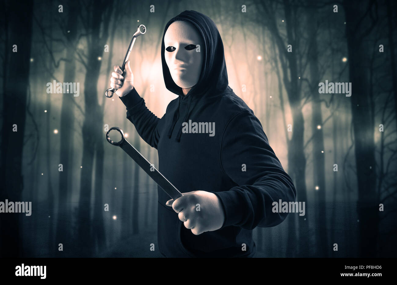 Masked armed hitman in dark thick forest with foggy mysterious concept ...