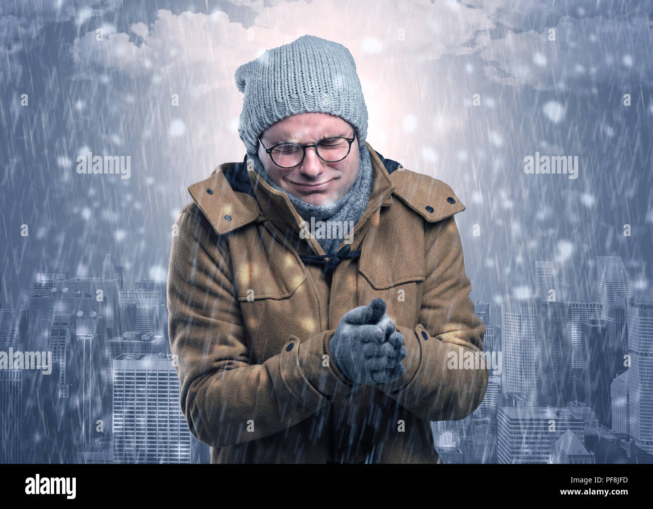 Young man freezing in warm clothing with city concept Stock Photo - Alamy